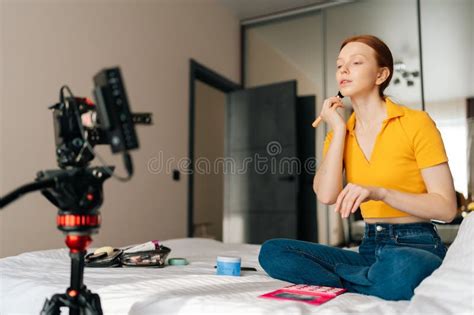 low angle view of redhaired female beauty blogger making video tutorial