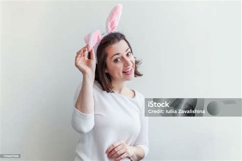 행복 한 부활절 휴일 축 하 봄 개념입니다 부활절 날에 고립 된 흰색 배경에 토끼 귀를 입고 젊은 여자 4월에 대한 스톡 사진