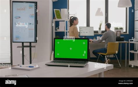 Close Up Of Laptop With Green Screen At Empty Desk In Office Computer With Chroma Key On