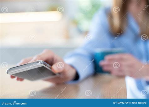 Woman Concerned About Excessive Use Of Social Media Laying Mobile Phone Down On Table Stock