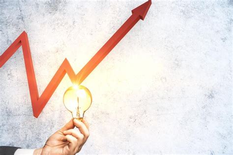 Premium Photo Hand Holding Lightbulb And Growing Red Arrow