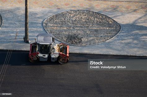 무거운 진동 롤러 압축기아스팔트 도로 롤러는 도로 건설 현장의 도로에 새로운 뜨거운 아스팔트를 누릅니다 아스팔트 포장 작업에서 무거운 진동 롤러 복구 0명에 대한 스톡 사진
