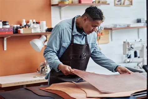 젊은 장인이 작업장에서 가죽을 검사하고 수공예품을 만드는 모습 공간을 복사하는 모습 사진 Unsplash의 중소기업 이미지