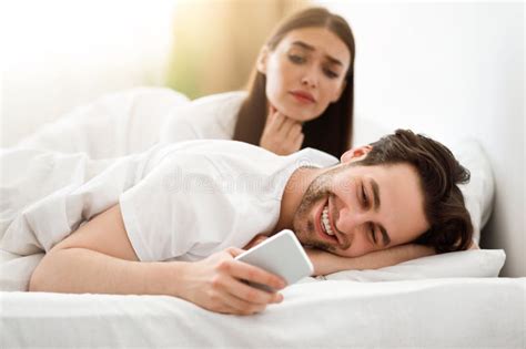 Wife Spying While Cheating Husband Texting On Cellphone In Bedroom Stock Image Image Of
