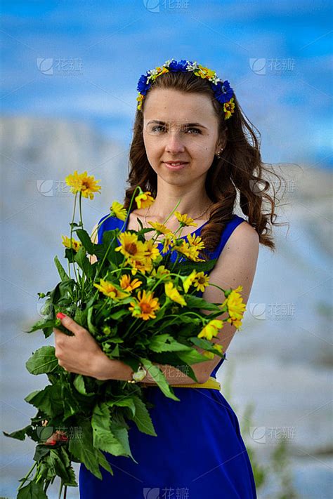 漂亮可爱的女孩穿着蓝色的裙子和黄色的花束