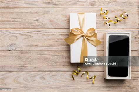 골드 리본과 스마트폰이 있는 기프트 박스를 컬러 배경 상단 보기로 오픈했습니다 빈 오픈 박스 포장 모형 디자인템플릿 브랜딩 모형 Brand Name Smart Phone에