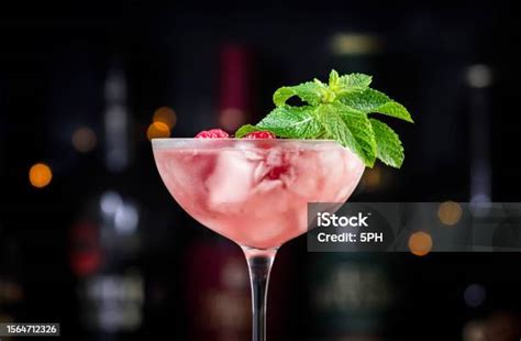 화이트 럼 설탕 시럽 과일 주스 라임 베리 얼음을 유리잔에 담은 라즈베리 다이키리 알코올 칵테일 검은색 바 카운터 배경 바 도구