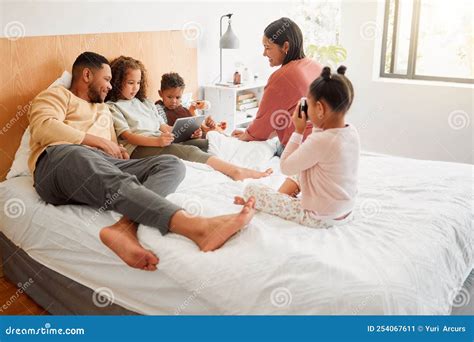 La Familia Feliz En El Dormitorio Mientras La Madre Y El Padre Juegan La Sonrisa Y Se Relajan
