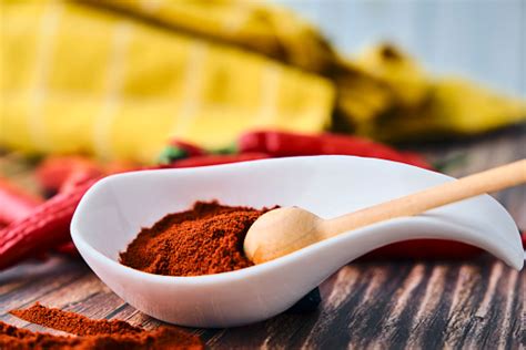 칠리 파우더와 파프리카 파우더는 붉은 뜨거운 칠리 페퍼 아시아 멕시코 및 스페인 음식 조미료와 나무 배경에 흰색 숟가락으로 가루로 빻은에 대한 스톡 사진 및 기타 이미지