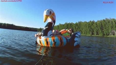 Alla Is Having A Great Time Swimming On A Large Bright Inflatable Swan On The Lake