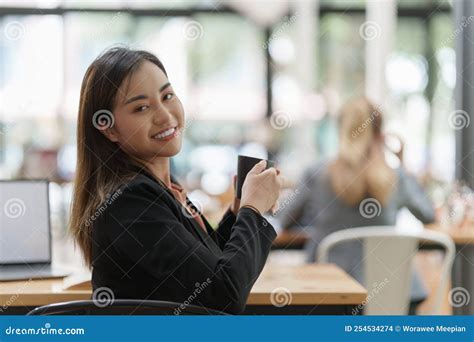 Positive Asian Secretary Smiling To Camera During Meeting At Office
