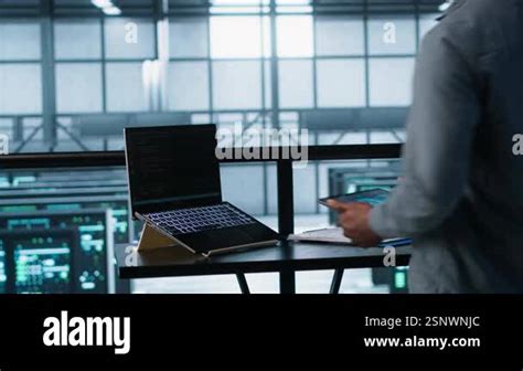 Admin Arriving In Data Center Using Artificial Intelligence Tech On Tablet And Laptop Man In