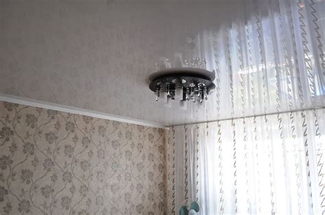 Белый глянцевый натяжной потолок в зале фото