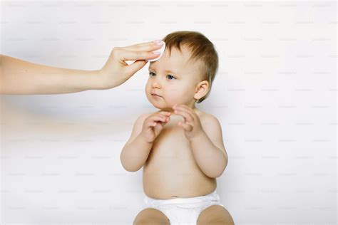 어머니 손은 흰색 배경에 면봉으로 1 년 여자 아기의 얼굴을 청소합니다 아기 위생 관리 건강 관리 의료 개념 사진 Unsplash의 코 이미지