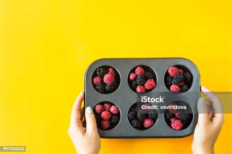 열매 나무 딸기 그리고 밝은 노란색 바탕에 여성 손에 컵 케이크를 제빵에 대 한 양식에서 블랙베리 여름 요리 개념입니다 평면도 뚱 뚱 하다 건강한 식생활에 대한 스톡 사진