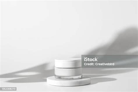 흰색 연단에 서 흰색 브랜드 화장품 크림 항아리 이국적인 식물의 그림자와 흰색 배경에 스킨 케어 제품 프리젠 테이션 트렌디 한