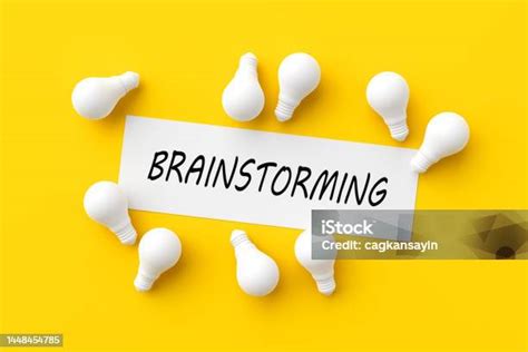 전구로 둘러싸인 흰 종이에 브레인 스토밍이라는 단어 비즈니스 창의성 및 노란색 배경에 브레인스토밍 개념 0명에 대한 스톡 사진