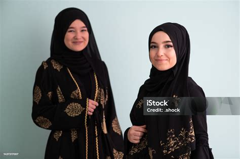 현대 이슬람과 라마단 카림의 개념을 나타내는 현대 청록색 배경에 고립된 히잡을 쓴 멋진 드레스를 입은 두 명의 아름다운 무슬림 여성 18 19세에 대한 스톡 사진 및 기타