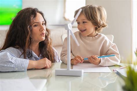 아들에게 재생 에너지에 대해 가르치고 집에서 소형 풍력 터빈 모델을 사용하여 풍력 발전 개념을 설명하고 호기심을 키우고 실습을 통해 학습하는 어머니 2 3 살에 대한 스톡