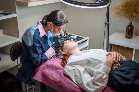 Premium Photo Procedure Of Eyebrow Microblading A Master In Black Gloves Is Doing A Blending