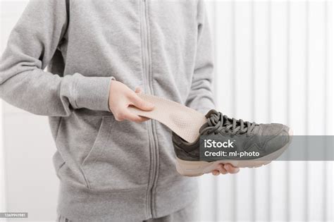 정형 외과 깔창과 운동화를 가진 스포츠웨어의 피트니스 여성 집에서 신발에 정형 외과 깔창을 넣어 여자 클로즈업 풋 케어 배너