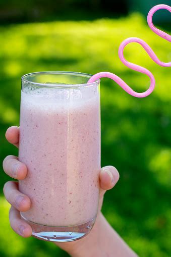 건강한 수제 밀크 쉐이크를 마시는 소녀 신선한 바나나 나 냉동 바나나와 딸기를 혼합하고 우유를 추가합니다 알몰드 귀리 또는 쌀 우유는 채식주의자에게 효과가 있습니다 설탕이