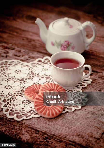 계란과 크림 수 제 비스킷 라운드 쿠키와 함께 중간에 구멍이 있는 나무 바탕에 작은 흰색 컵과 차 냄비에 홍차 핫 0명에 대한