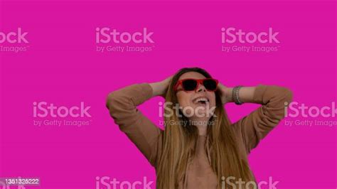 색칠한 배경을 가진 한 젊은 여성의 미친 초상화가 선글라스와 겨울 모자를 들고 전화를 들고 셀카를 찍고 있습니다 20 29세에 대한 스톡 사진 및 기타 이미지 Istock