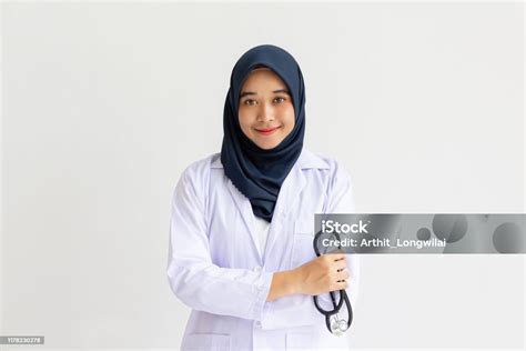 젊은 아랍 무슬림 인턴 의사 여성은 의료 병원 건강 관리에서 일하는 이슬람 사람들을위한 백색 배경 개념을 고립시키는 미소 현대 간호사는 메디코 클리닉 비즈니스 서비스에서