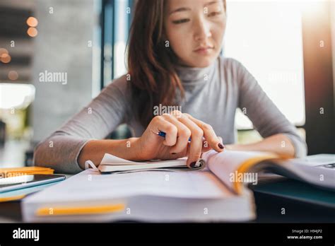 Close Up Image Of A Young Female Student Doing Assignments In Library