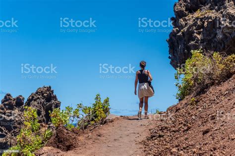 카나리아 제도 라 플라마 섬 동쪽에 있는 노갈레스 해변으로 여름에 길을 따라 걷고 있는 한 젊은 여성 스페인 35 39세에 대한 스톡 사진 및 기타 이미지 Istock