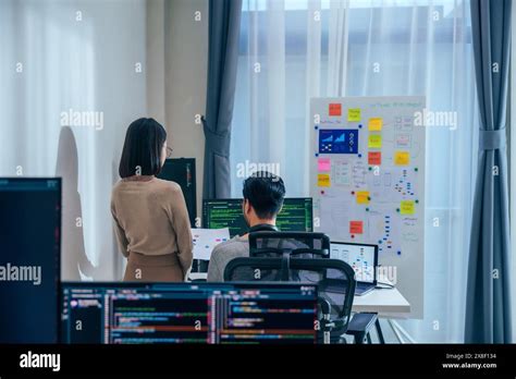 asian software developer discussion about coding project on computer screen at moden office