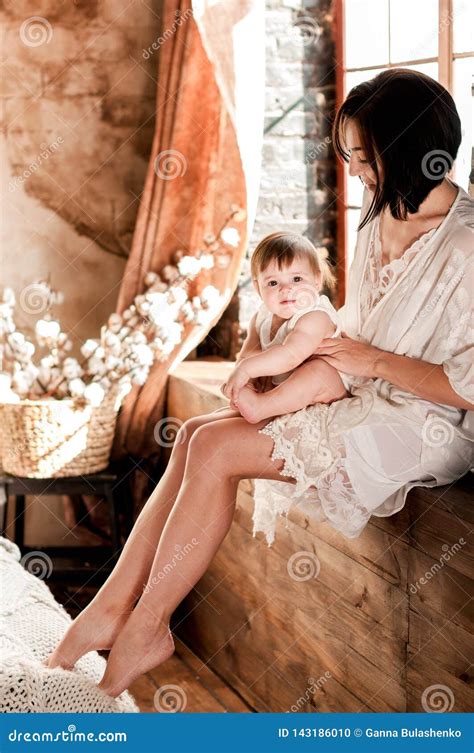 Junge Schöne Mutter Sitzt Auf Einem Hölzernen Fensterbrett Das Ihre Kleine Tochter Hält