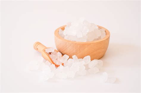 화이트 캔디 바위 설탕 또는 크리스탈 설탕 나무 특종과 흰색 배경에 고립 된 나무 그릇 하얀 암석 설탕은 녹은 다음 반투명 원석으로 결정화됩니다 각설탕에 대한 스톡 사진 및