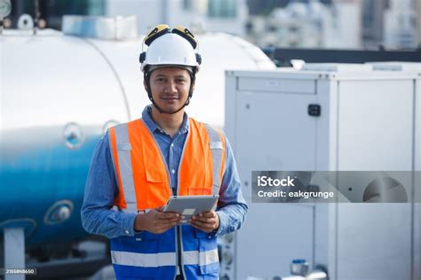 옥상 건물 공사에서 태블릿을 들고 일하는 아시아 남자 엔지니어 사무실 건물의 Hvac를 점검하는 남성 기술자 노동자 대형 에어컨