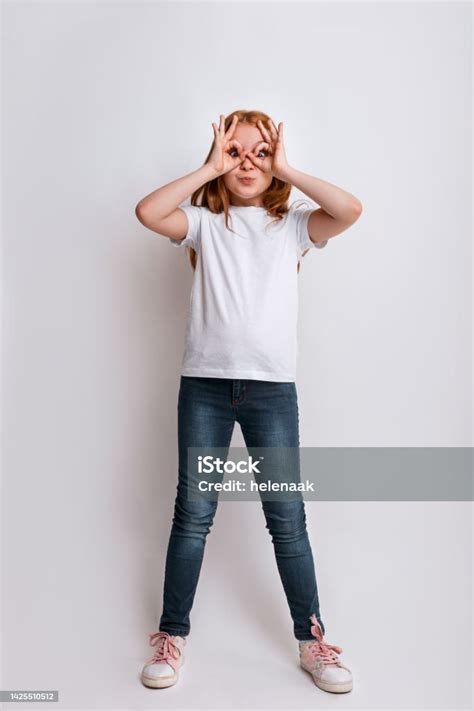 하얀 티셔츠를 입은 마스크 형태로 눈 가까이에서 손을 잡고 있는 쾌활한 빨간 머리 소녀 십대 소녀에 대한 스톡 사진 및 기타