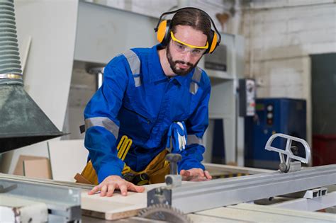 공장 작업장에서 나무 판자를 자르기 위해 전자 톱 기계로 일하는 남성 목수 나무로 되는 공장의 생산 라인 제조 산업의 Cnc 자동 목공 기계 20 24세에 대한 스톡 사진