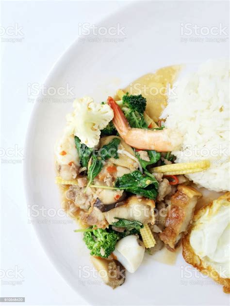 저 어 튀김된 파 삭 파삭한 돼지 새우 해산물 타이어 거룩한 바 질 고추 마늘 그리고 간장 소스와 함께 태국 쌀과 흰 접시에