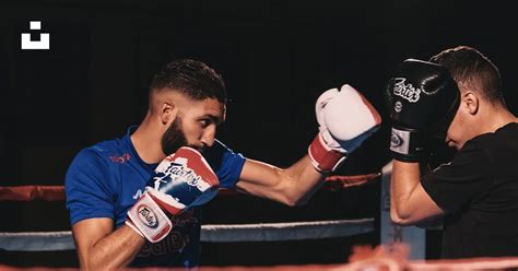 파란색과 빨간색 저지 셔츠를 입은 남자가 흰색과 빨간색 권투 글러브를 들고 있다 사진 Unsplash의 무료 클립 이미지