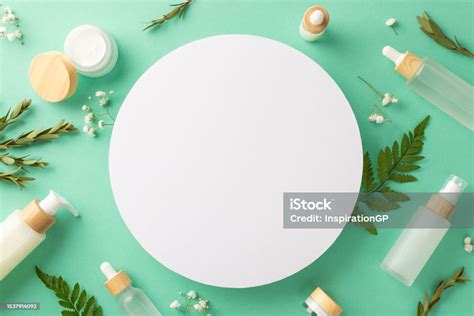 건강한 스킨케어 화장품 개념 화장품 용기와 고사리 유칼립투스 석고 나뭇가지가 있는 빈 원형 프레임의 위 보기 사진은 복사 공간이 있는 고립된 청록색 배경에 있습니다 0명에