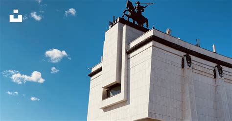 낮 동안 흰색 콘크리트 건물 위로 날아가는 검은 색과 빨간색 새 사진 Unsplash의 무료 건물 이미지