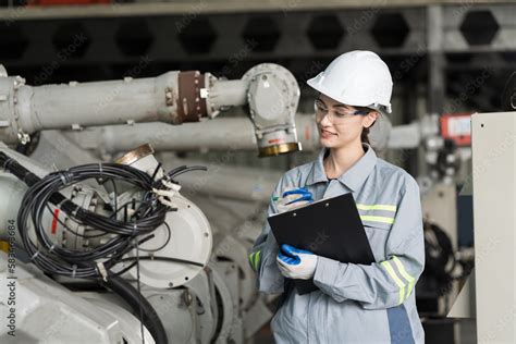 industrial manufacturing robotic arms maintaining female engineer