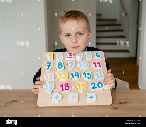 The Boy Learns To Count Holds A Board With Numbers Puzzles Arranged In