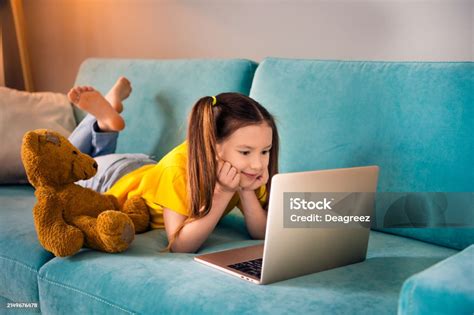 Photo Portrait Of Adorable Small Girl Lying Sofa Netbook Watch Cartoon