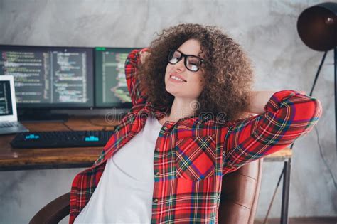 Young Female Programmer Relaxing In A Home Office Workspace With Coding Screens And Showcasing A