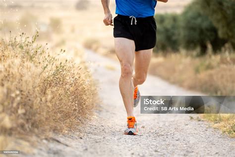 남자 선수 다리와 극단적인 크로스 컨트리 남자 실행 하 고 농촌 트랙 시골 스포츠와 건강 한 라이프 스타일에 가혹한 햇빛 및 렌즈 플레어 석양에 조깅에 대 한 교육의 발을