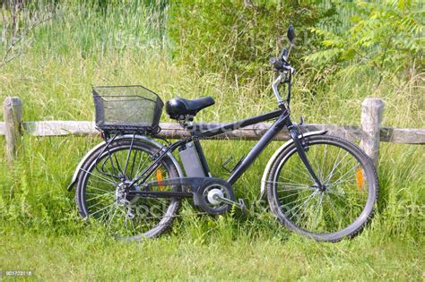 화창한 여름 날에 공원에 나무 울타리에 전기 자전거 측면에서 촬영 필터링 되지 않은 자연 스러운 조명 전자 모터 배터리 전원 및 장비의 보기 0명에 대한 스톡 사진 및 기타