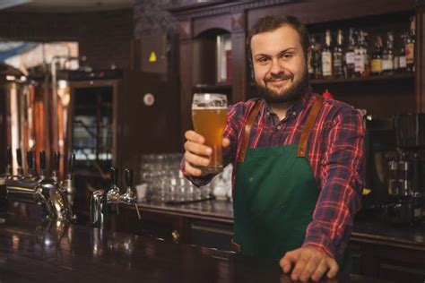 Friendly Bartender Smiling While Serving Beer At His Pub Beer Business Finance