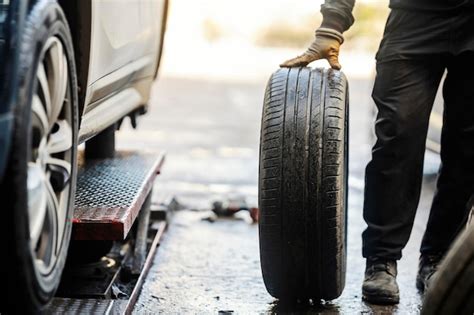 Premium Photo Cropped Picture Of A Vulcanizing Worker With Car Tire In Workshop