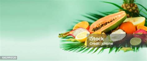 청록색 바탕에 이국적인 과일의 구색입니다 배너입니다 해독 채식주의 음식 여름 개념입니다 파파야 망고 파인애플 Carambola 드래곤 과일 키 위 오렌지 멜론 코코넛 팜